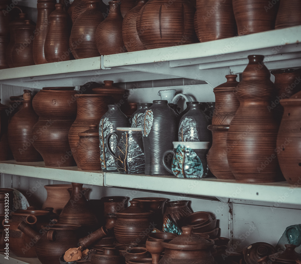 racks in a pottery workshop with pottery, many different pottery ...