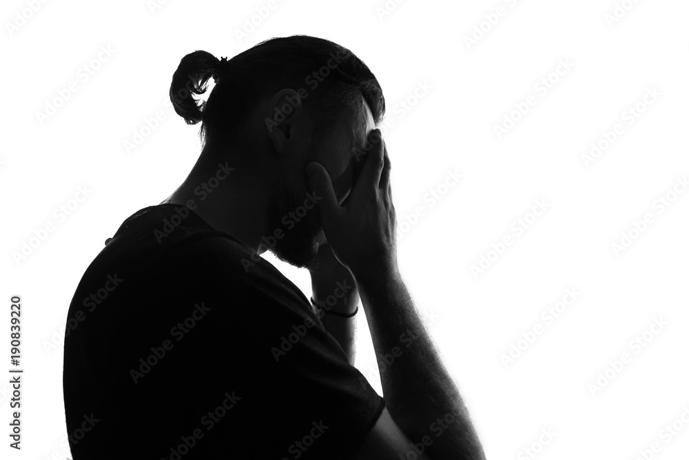 Male person silhouette crying and covering the face with the hands ...