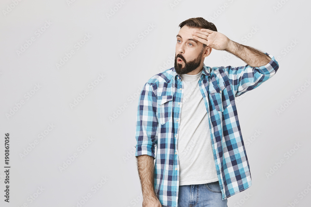 Adult bearded guy wiping his forehead with hand making phew gesture ...