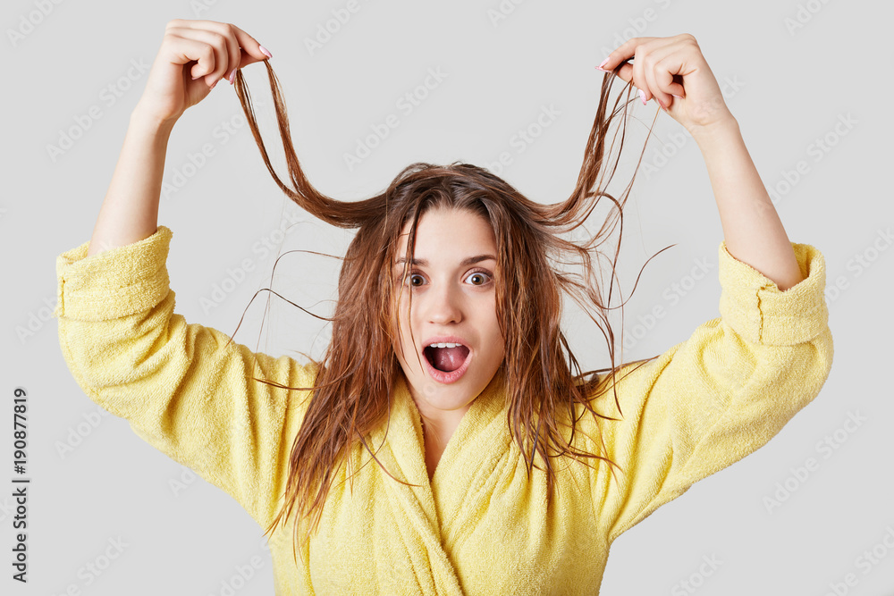 Shocked young female has unmanageable hair after taking shower, doesn`t ...