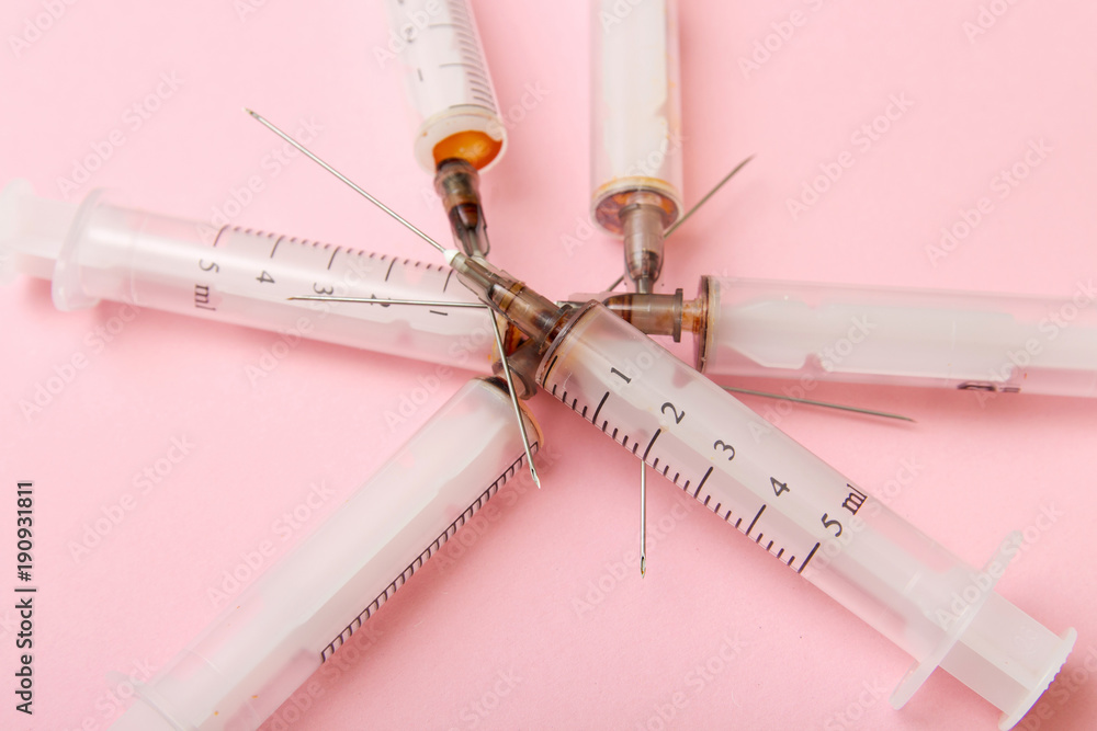 Used syringes on a pink background. Heroin Epidemic. The preparation of ...