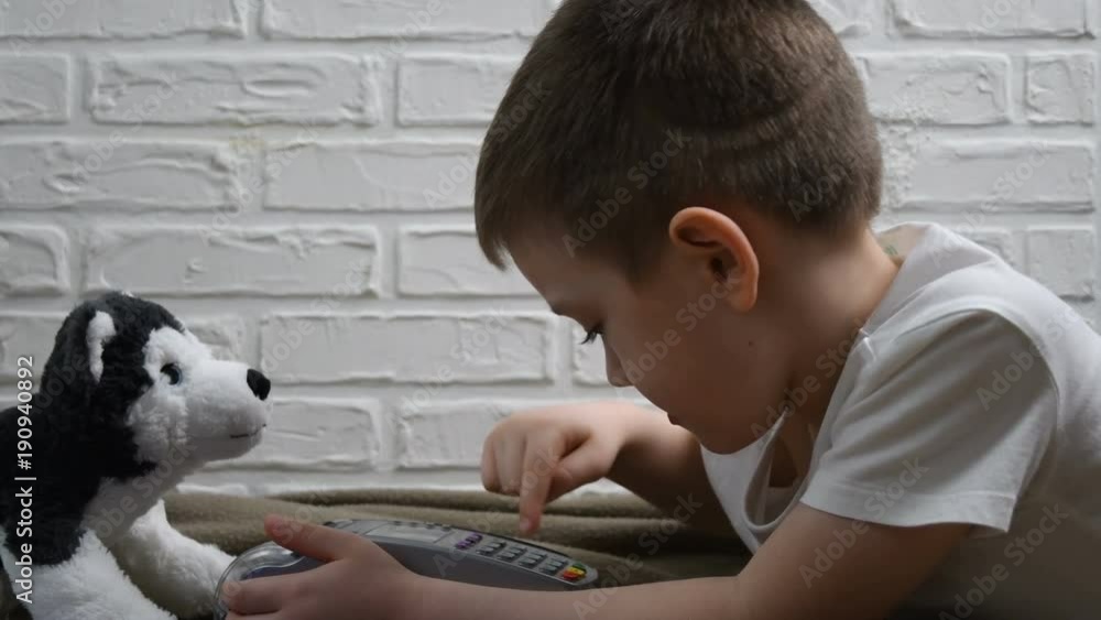 Young boy lieing on the floor pressing pos terminal buttons. Modern ...