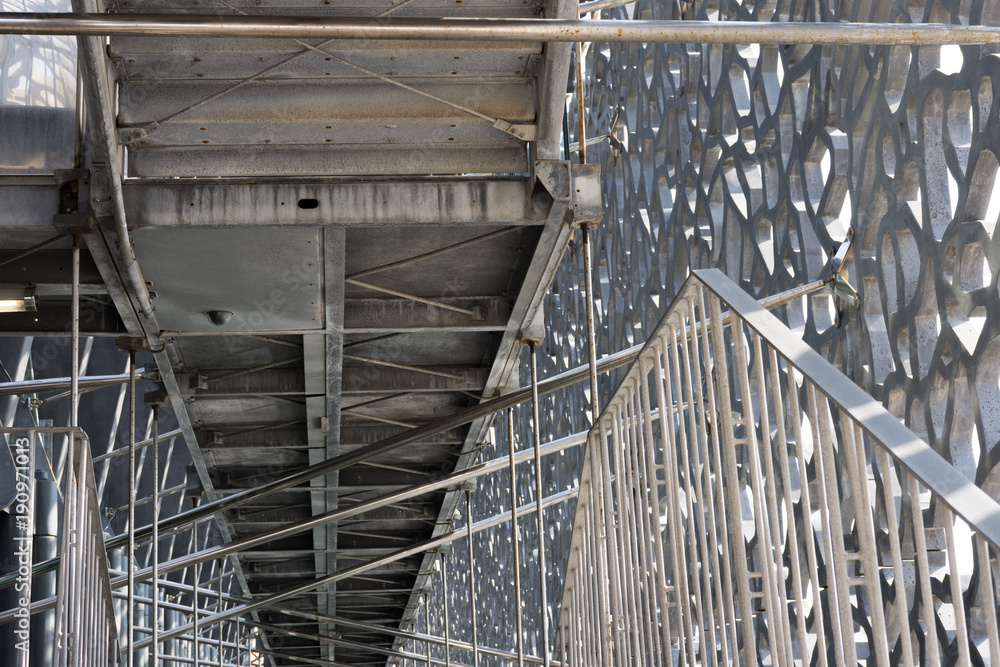 Concrete lattice work, steel pipe beams and a suspended metal sidewalk ...