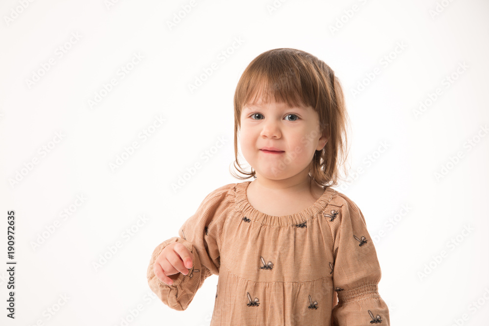 Cute little girl in beige dress isolated on white background. Portrait ...