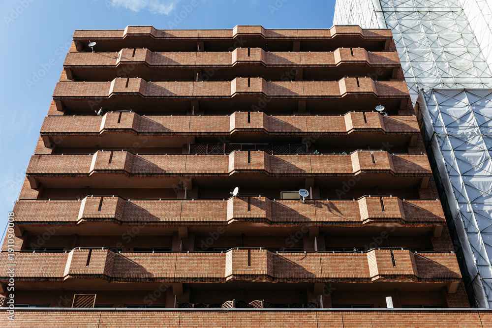 Brick building facade view from below with sunlight and shadow in ...
