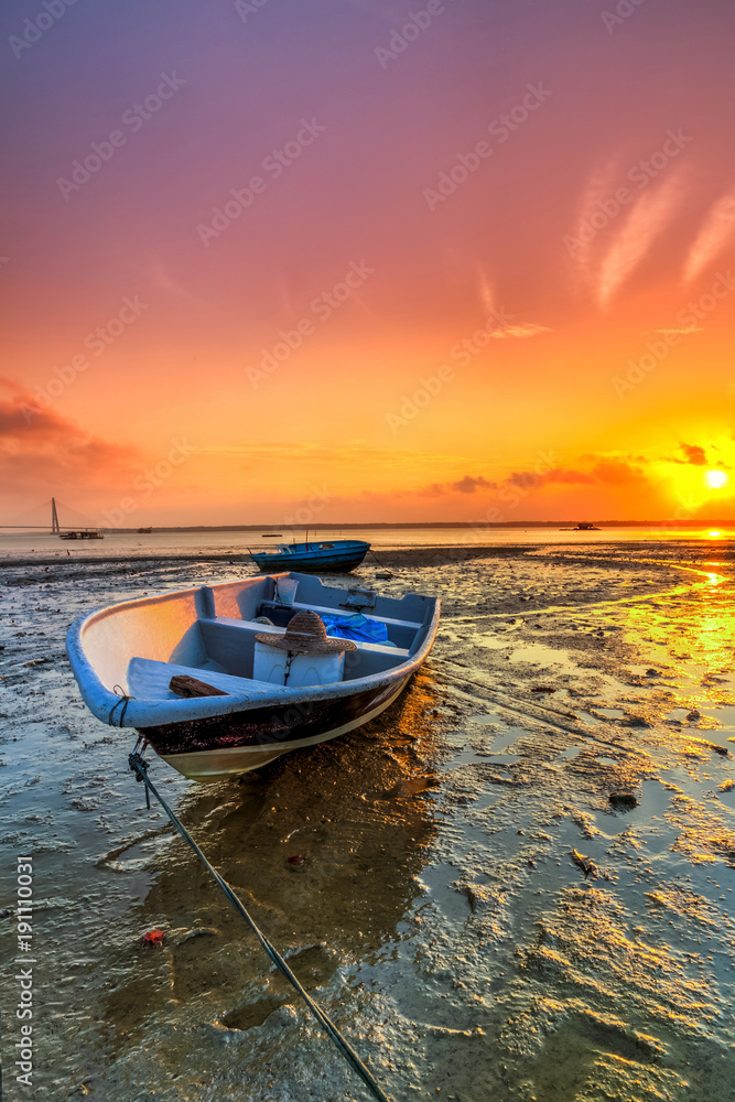Long exposure picture of fishing boat with golden sunset as a ...