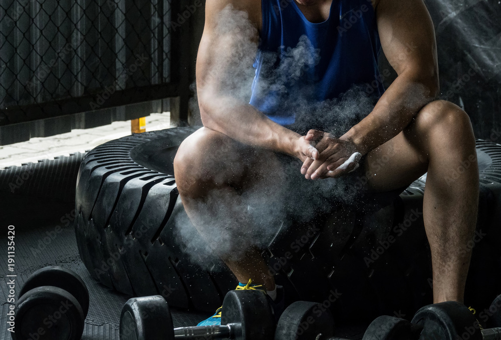 Muscular weightlifter clapping hands and preparing for workout at a gym ...