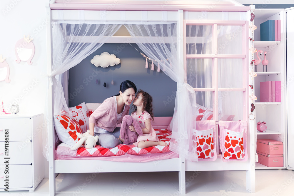 Cute little girl and her mother play in the bedroom Stock Photo | Adobe ...