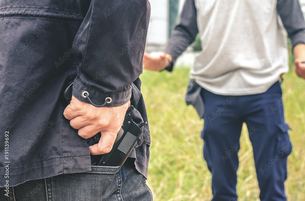 Close up back view of bandit catch a hidden gun,A man holding a gun in ...