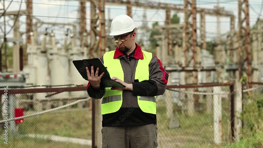 Electrician with computer on power station. Factory worker with tablet ...
