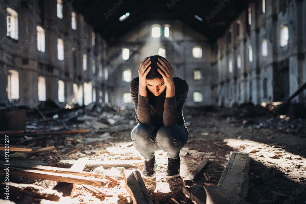 Sad depressed person in abandoned destroyed building crying.Emotional ...