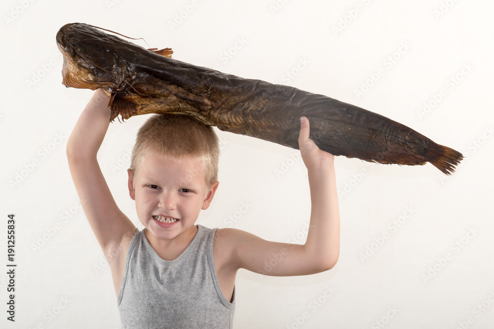 The little boy shows what a big fish he caught in the river. The ...