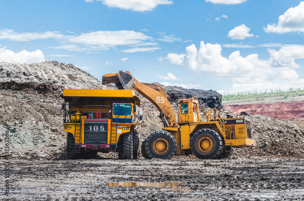 Excavator loading of coal, ore on the dump truck. The big dump truck is ...