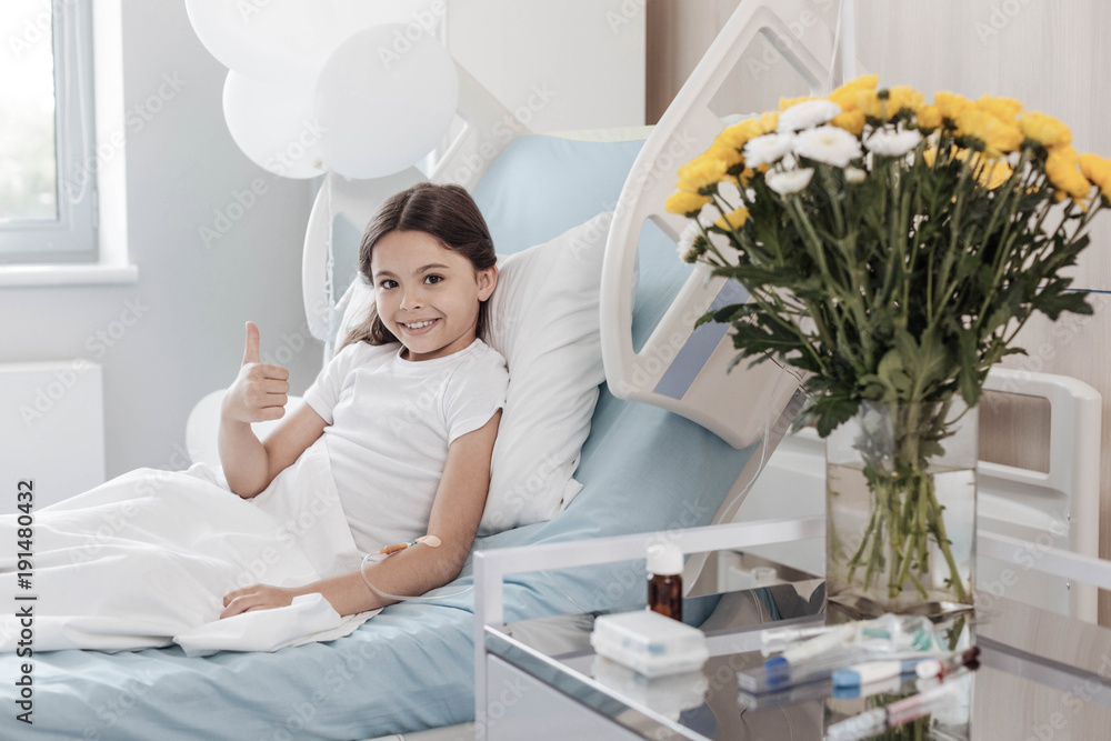 Getting better. Cheerful kid smiling and gesturing with a super sign ...