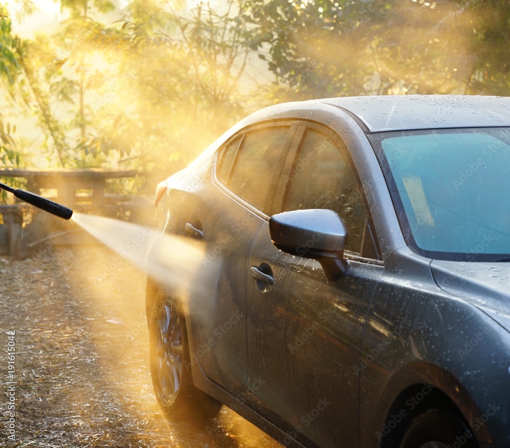 Car Washing. Cleaning grey color car using high pressure water in the ...
