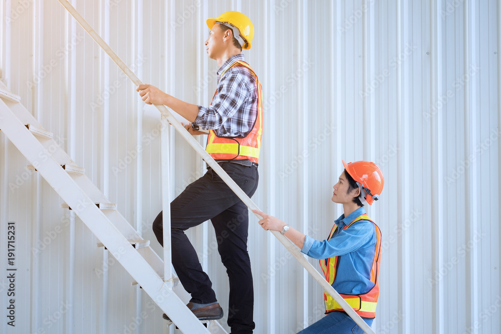 Male and female engineers are walk up the staurs for exploring the ...