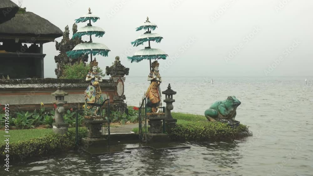 statues of hindu two deities and a large statue of frog at ulun danu ...