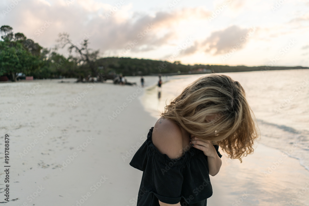 beautiful young woman spending her day at the beach and looking at the ...