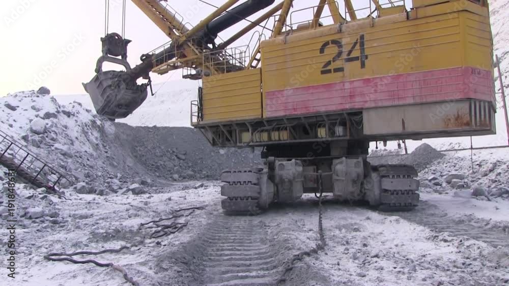 The excavator goes and pulls the electric cable. Heavy excavator in the ...