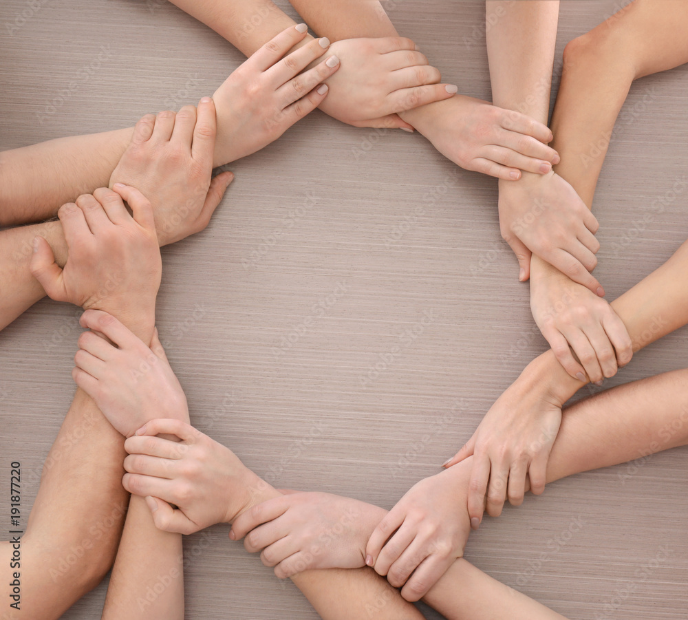 Group of people making circle with their hands on wooden background ...