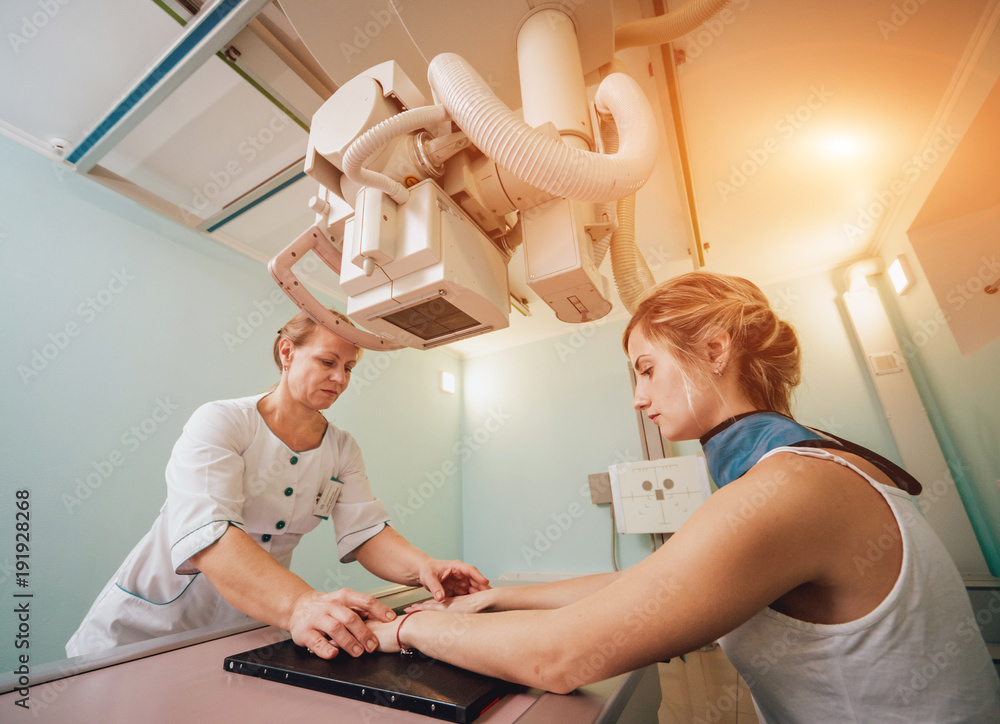 Radiologist and patient in a x-ray room. Classic ceiling-mounted x-ray ...