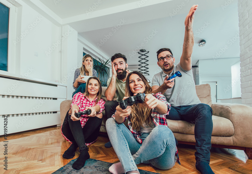 Group of friends play video games together at home, having fun. Stock ...