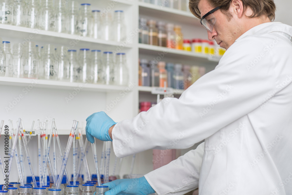 Lab worker taking dye from beaker using long pipette Stock Photo ...