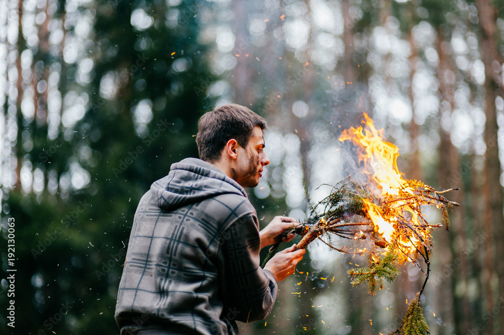 Happy funny crazy fearless man holding burning firewood in hands ...