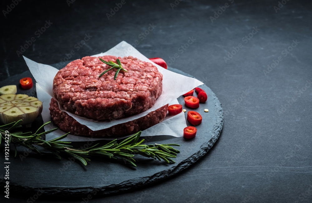 Raw burger cutlet from beef meat with garlic and rosemary on black ...