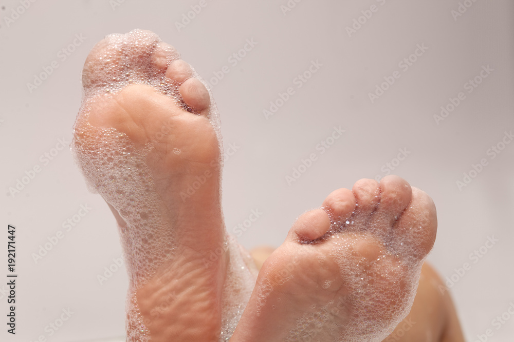 women feet with foam bath on white background Stock Photo | Adobe Stock