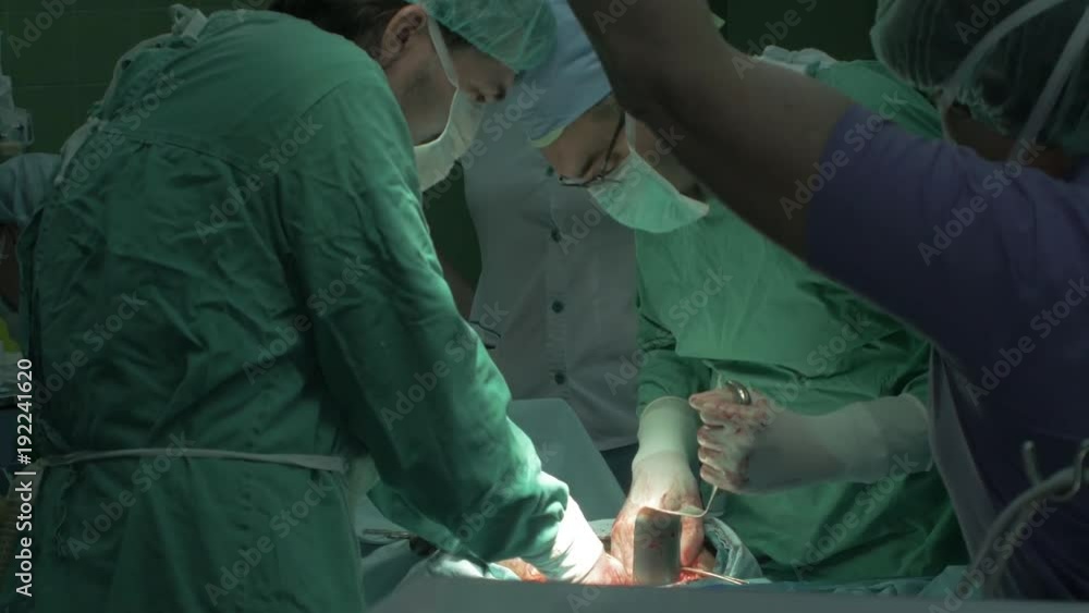 Surgical procedure, a team of male surgeons with help of female medical ...