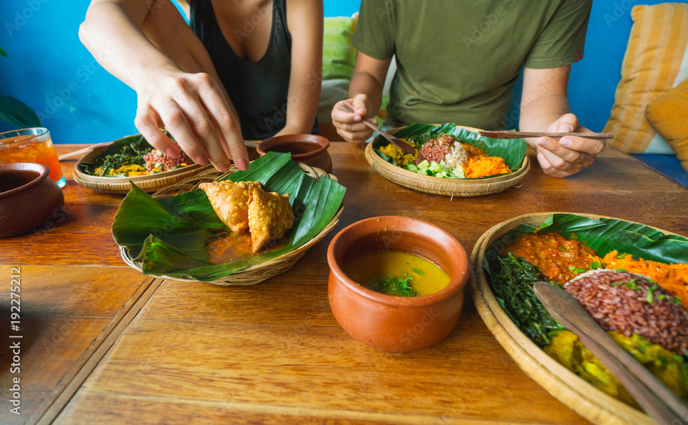 Vegetarian Indian food. several people eat Indian food at a common ...