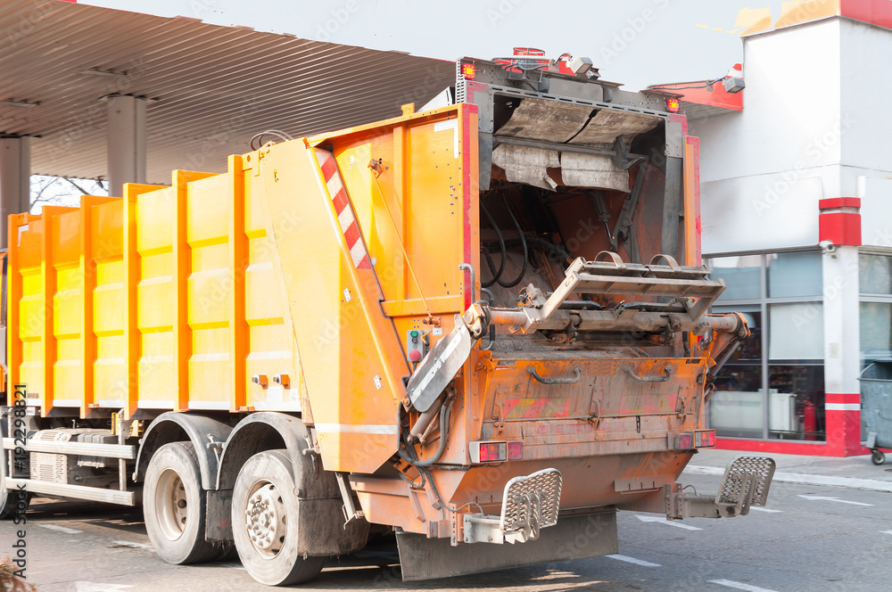 Rear end of garbage dumper truck on the way to waste dumpster cans ...