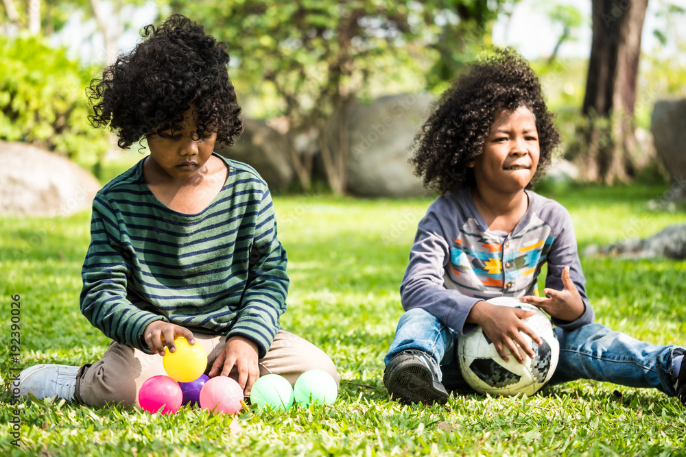 Kids playing balls together. Group of children sitting on grass in a ...