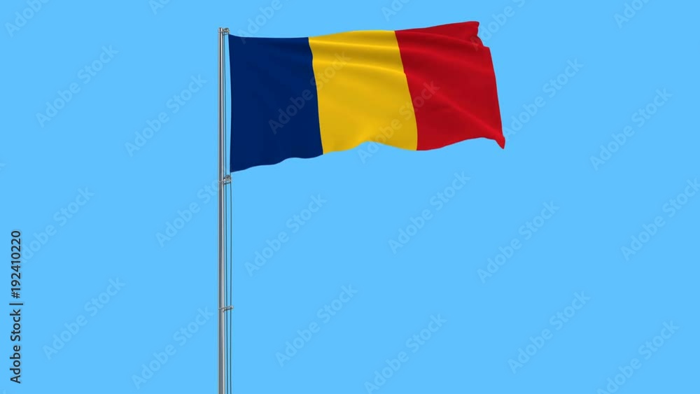 Flag of Romania on the flagpole fluttering in the wind on a pure blue ...