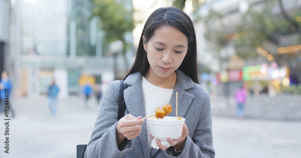 Woman eating fish ball, Hong Kong style snack Stock Photo | Adobe Stock