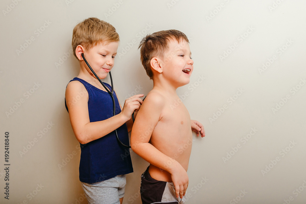two boys playing doctor with Stethoscope on white background, baby ...
