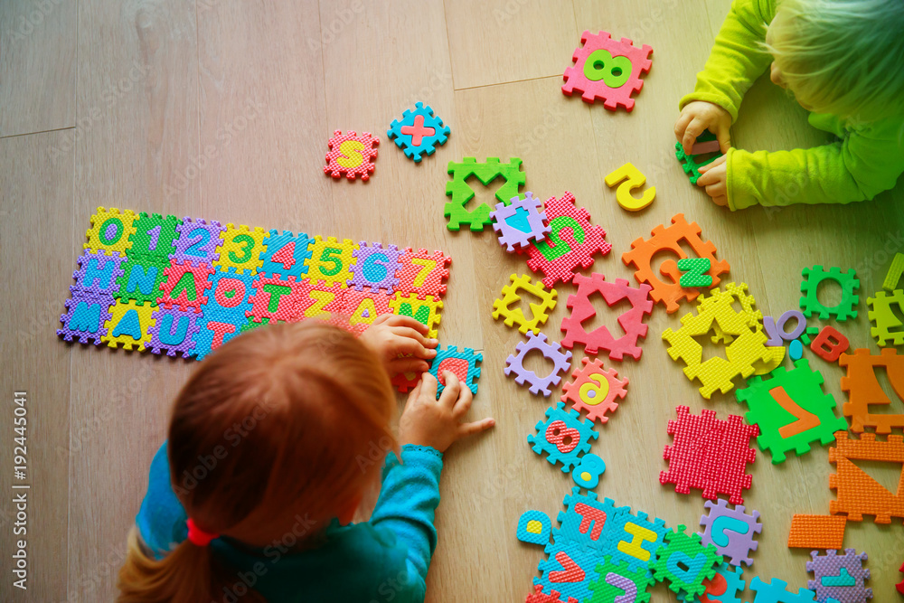 kids playing with puzzle, learning numbers and shapes Stock Photo ...