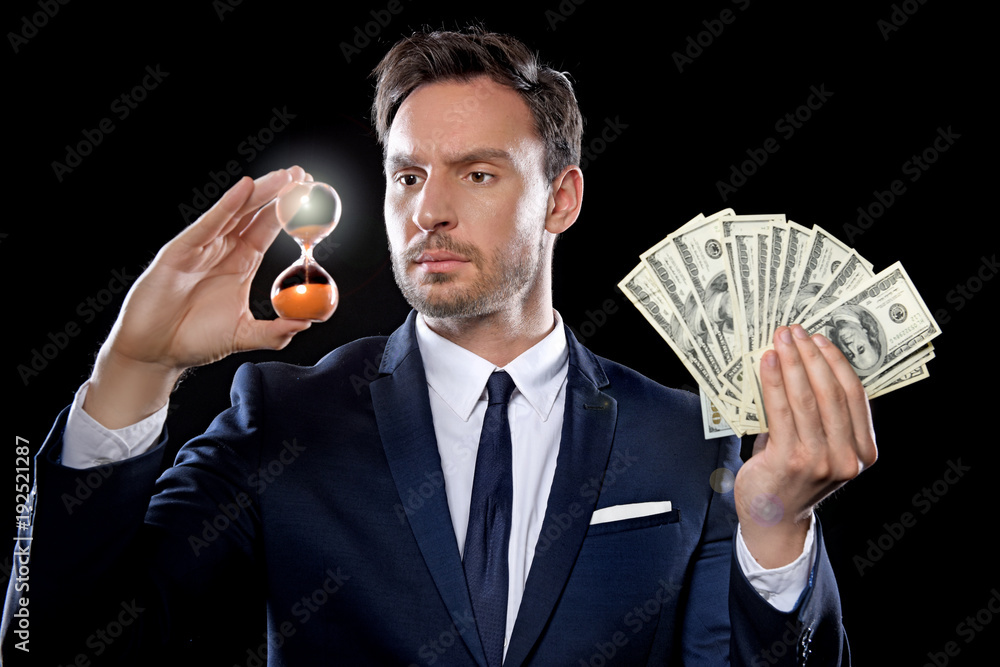 Handsome smart businessman in a suit holding stack of money and a ...