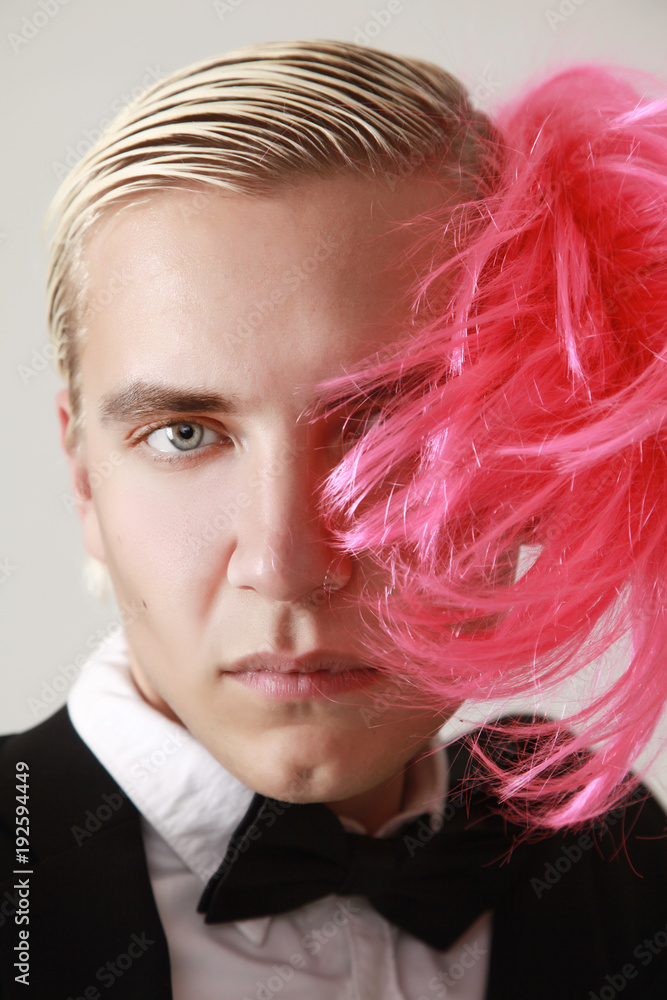 stylish and funny young guy standing in business suit and pink women ...