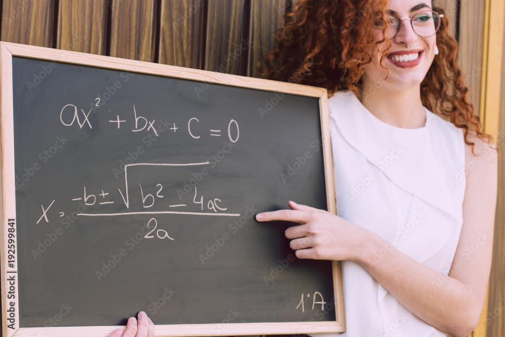 Profesora joven enseñando una lección de matemáticas Photos | Adobe Stock
