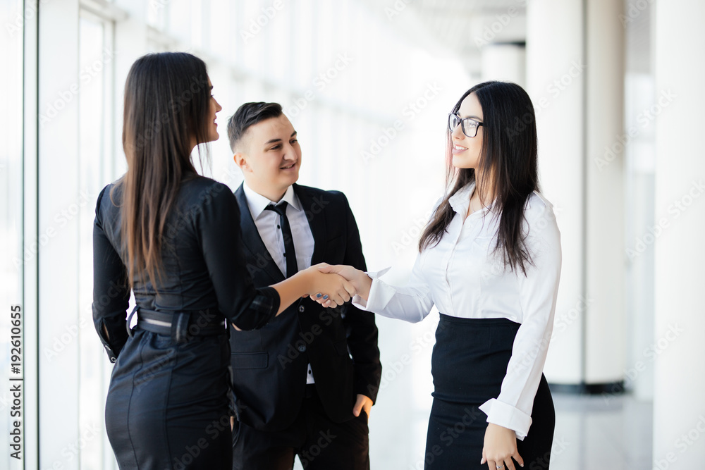 Business partners shaking hands in meeting hall. Two business woman ...