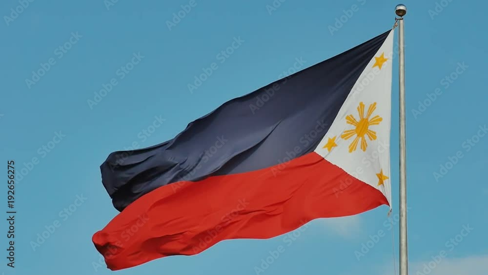 Flying bicolor flag of the Philippines with central golden sun ...