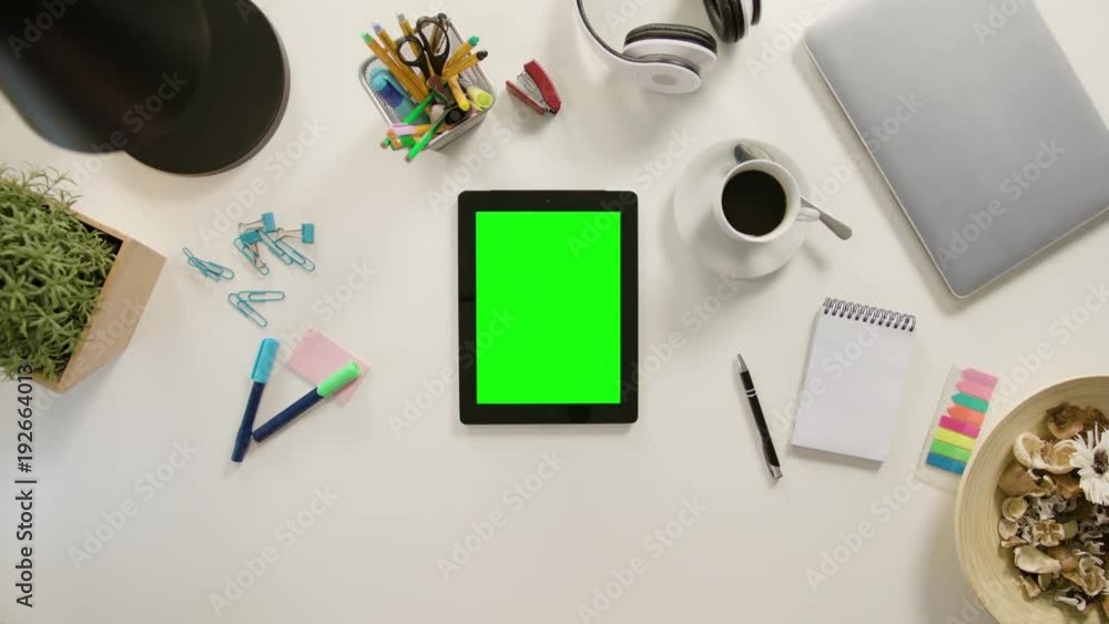 A finger touching a tablet with a green screen. The tablet is on the ...