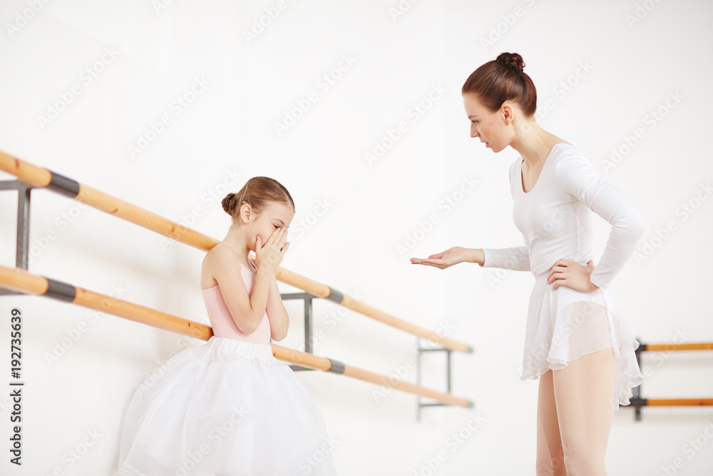Strict ballet teacher expressing her dissatisfaction while talking to ...