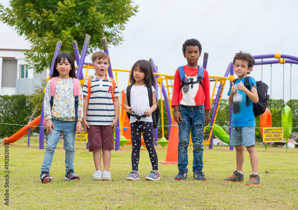 group of diversity school children playing at playground in ...