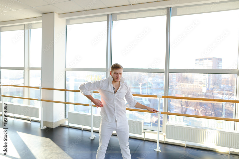 Guy in black suit doing one arm handstand. Male person dancing at gym ...