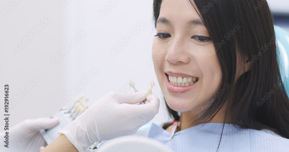 Woman compare the color of tooth sample Stock Photo | Adobe Stock