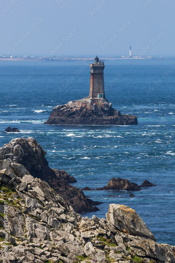 Rocky promontory Pointe du Raz and old lighthouse Phare de la Vieille ...