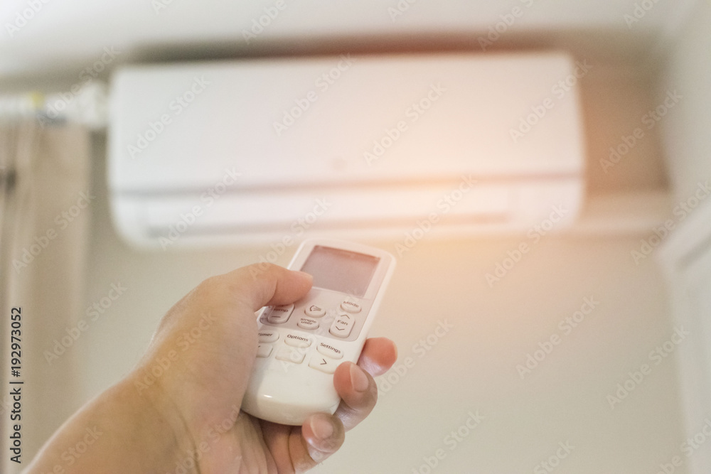 Hand hold remote to turning off air conditioner Stock Photo | Adobe Stock
